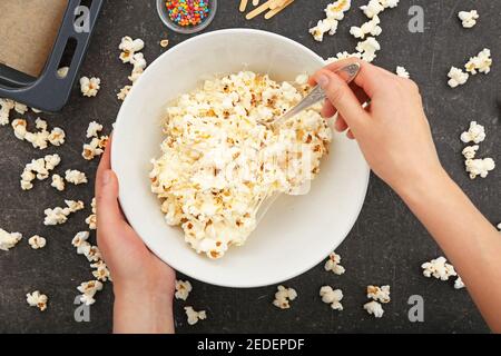 Woman making tasty popcorn balls, top view Stock Photo - Alamy