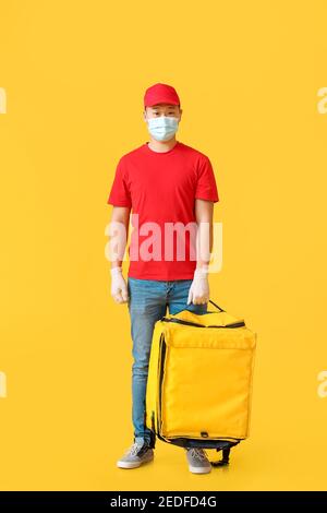 Handsome asian worker with protective mask and yellow helmet standing ...