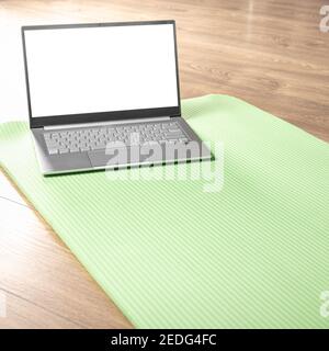 Computer with blank screen and grey mat on white desk in office ...