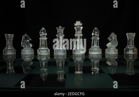 full set of eight clear chess piece isolated on a chequered chess board ...