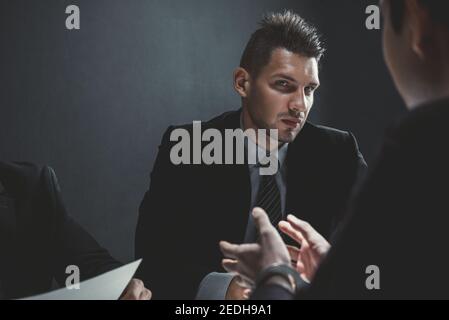Detective interviewing suspect in dark private room - investigation and ...