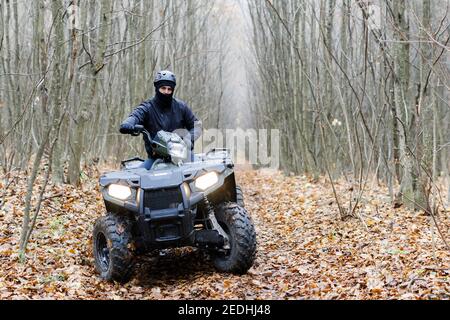 A man rides by on a quad bike past a row of Greenlandic national flags ...
