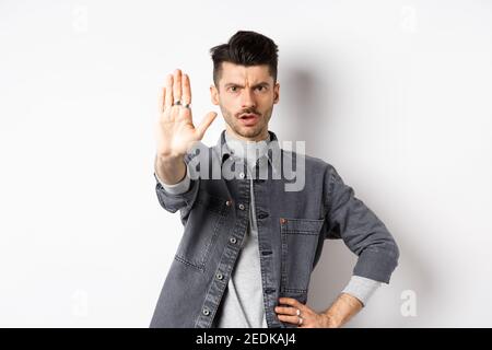 Serious caucasian man tell no, showing cross stop gesture and looking ...