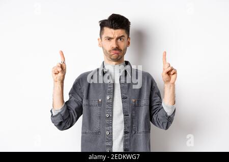 Confused funny guy with moustache pointing fingers up at something ...