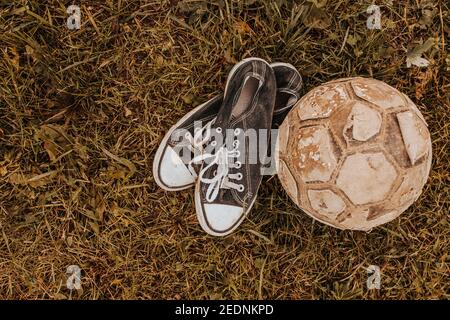 Vintage worn out soccer gear - old tattered ball and sneakers ...
