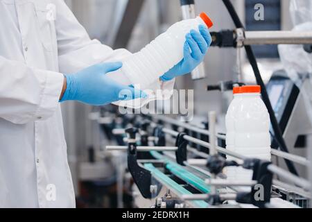 Female chemical plant process operator walkway to storage tank pipes ...
