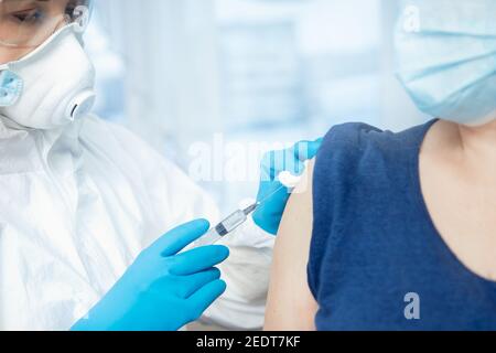 Nurse giving intramuscular injection of medicine into patients buttock ...