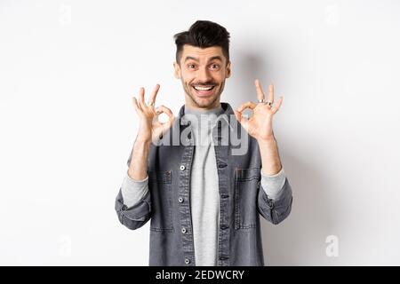 Happy guy say yes, smiling and showing okay signs, like good product ...