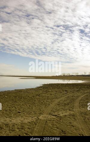 Empty bay of a lake reflecting the cloudy sky Stock Photo - Alamy