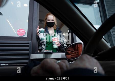 server at Starbucks Drive Thru window taking or receiving coffee travel ...