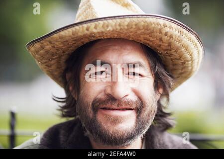 Smiling mature european male with beard in glasses and headphones works ...