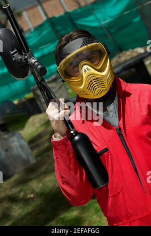 Paintball, gun and man with focus, safety uniform and extreme sports ...