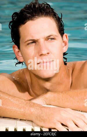 Young hispanic man tired leaning on table with cleaning products at ...