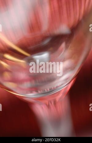 Close-up of glass with alcoholic drink on background of flashing colors ...