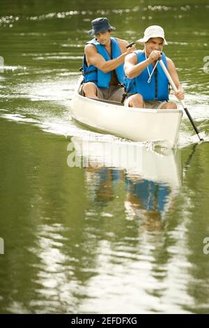 Two mid adult men boating in a lake Stock Photo - Alamy