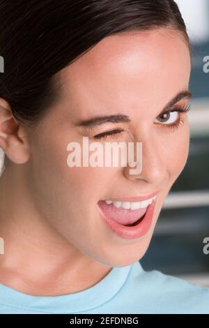 cheerful mixed race woman winking at camera isolated on blue Stock ...