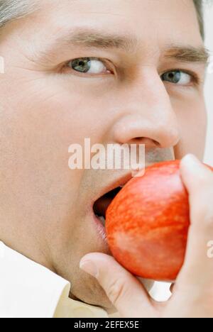 Man, face and profile, eating apple with nutrition, food and health ...