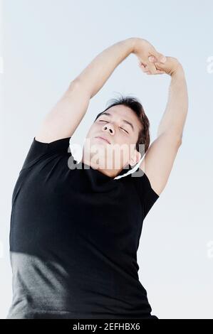Young hispanic man stretching arms muscles outdoors Stock Photo - Alamy