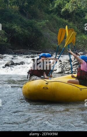 Side profile of four people rafting in a river Stock Photo - Alamy