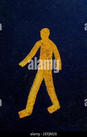 Yellow pedestrian road safety walkway sign painted a road in a car park ...