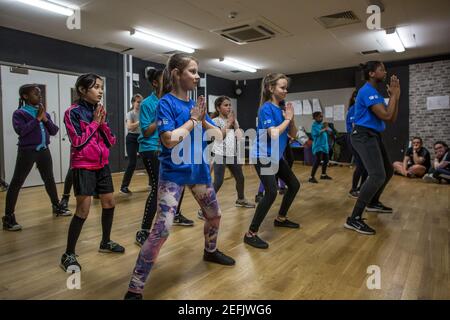 Schoolchildren participate in an indoor Physical Education (PE) lesson ...