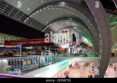 Luggage trolleys and an Emirates billboard at the drop-off zone of ...