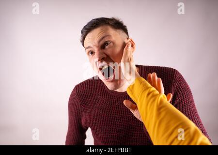 Crop person slapping scared man in face. Emotional male getting slapped ...