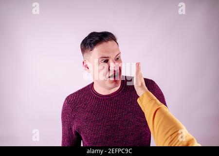 Crop person slapping scared man in face. Emotional male getting slapped ...