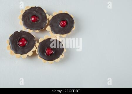 Tartalettes with chocolate ganache and red cherry Stock Photo - Alamy