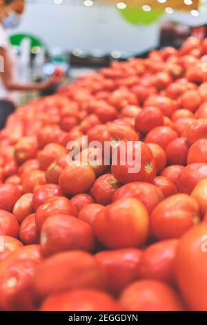 Young woman choosing tomatoes in grocery store Stock Photo - Alamy