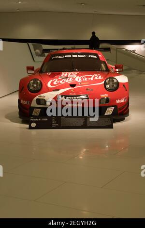 Red racecar with sponsors on display at the Porsche museum in Stuttgart ...