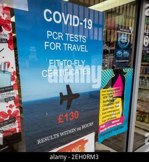 A poster in the window of a pharmacy offering commercial Covid-19 PCR ...