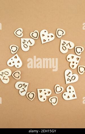 Round frame of craft paper hearts and circles on wooden background ...
