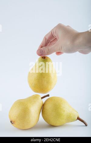 Woman holding ripe pear on white background Stock Photo - Alamy