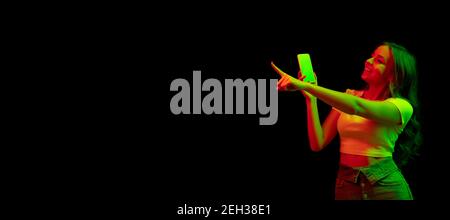 Pointing, flyer. Young caucasian woman's portrait on gradient blue ...