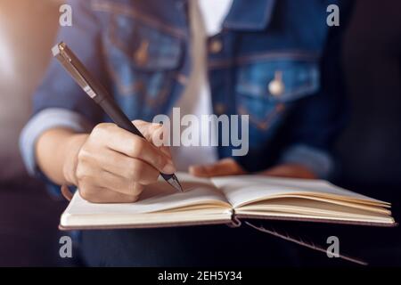 Businesswoman makes a note in notebook Stock Photo - Alamy