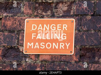 Beware falling masonry warning sign in a churchyard at Brancaster ...