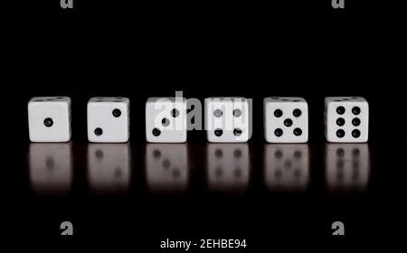 Six dice, all showing six, on a table with reflection and black ...