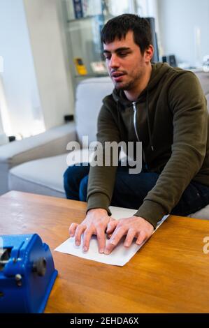 Blind male reading braille language book at library. Selective focus ...