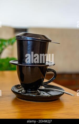 Vertical photo of Vietnamese black colored metallic coffee dripping ...