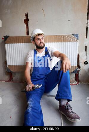 handsome heating engineer with hand resting on pickaxe Stock Photo - Alamy