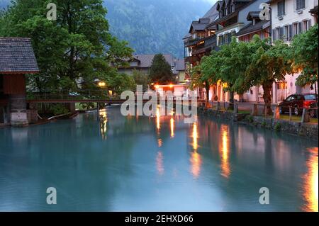 Switzerland, Interlaken. Evening view of a small river and the railroad ...