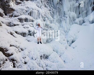 Man in traditional Japanese shugendo outfit doing waterfall meditation ...