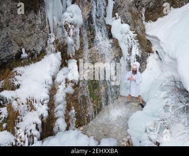 Man in traditional Japanese shugendo outfit doing waterfall meditation ...