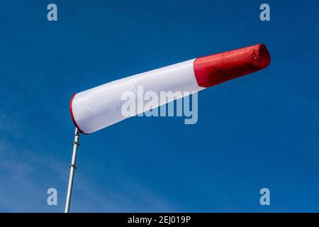 Wind sock indicating strong breezes against a clear blue sky at an ...