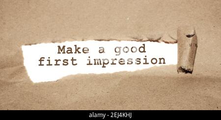 The text Make a good first impression appearing behind torn brown paper ...