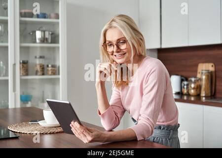 Middle age woman ecommerce business worker using smartphone holding ...
