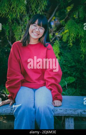 Black female teenager wearing eyeglasses holding books while standing ...
