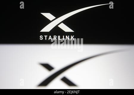The Starlink logo is seen on a mobile device with a Ukrainian flag in ...