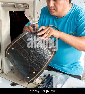 Leather handbag craftsman at work in a vintage workshop. Small business ...